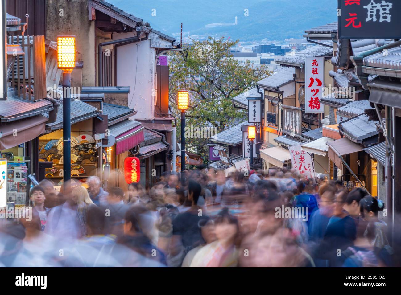 View of busy street and traditional wooden houses and shops in Gion ...