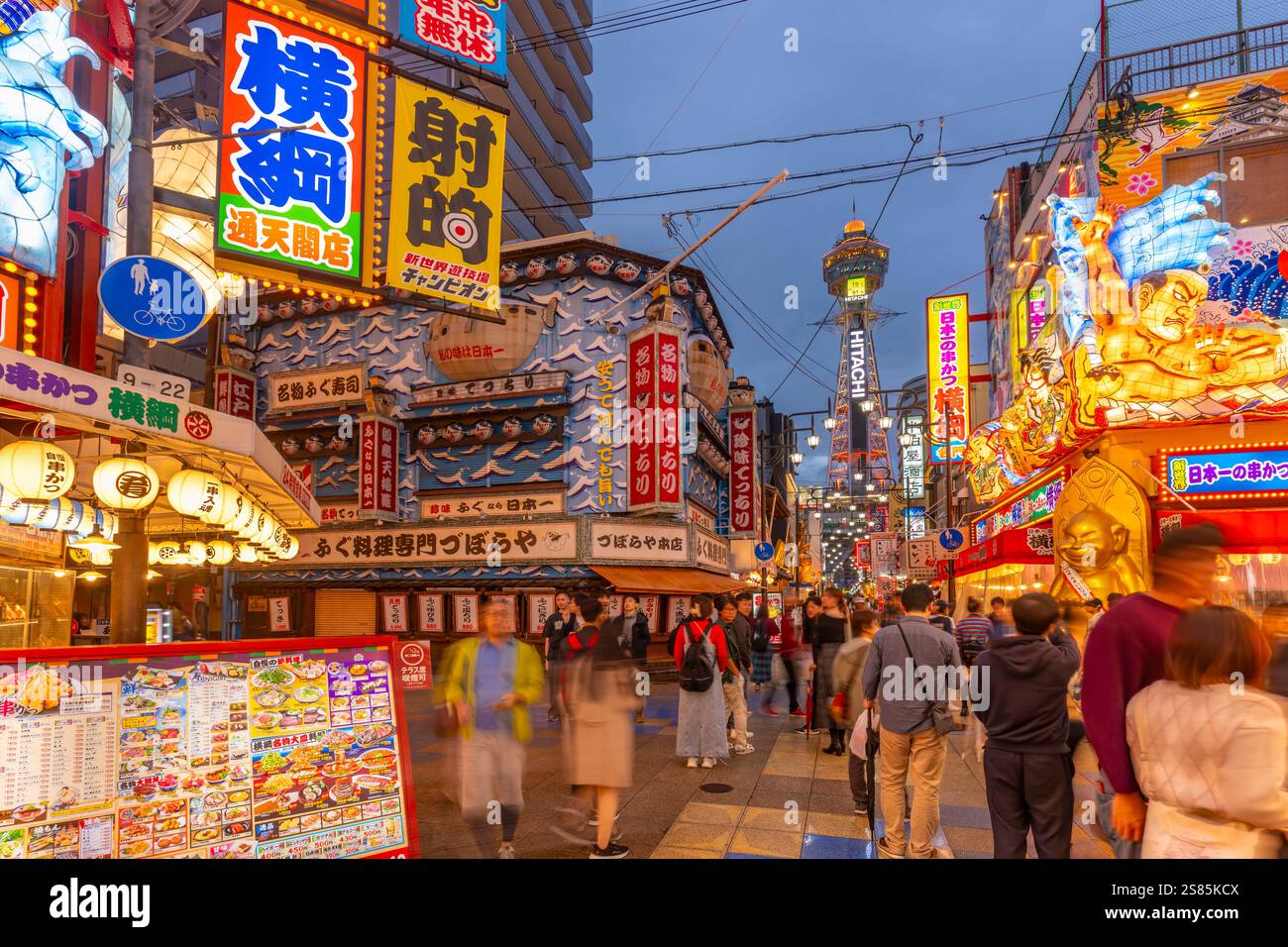 View of Tsutenkaku Tower and restaurants neon lights at dusk in the ...