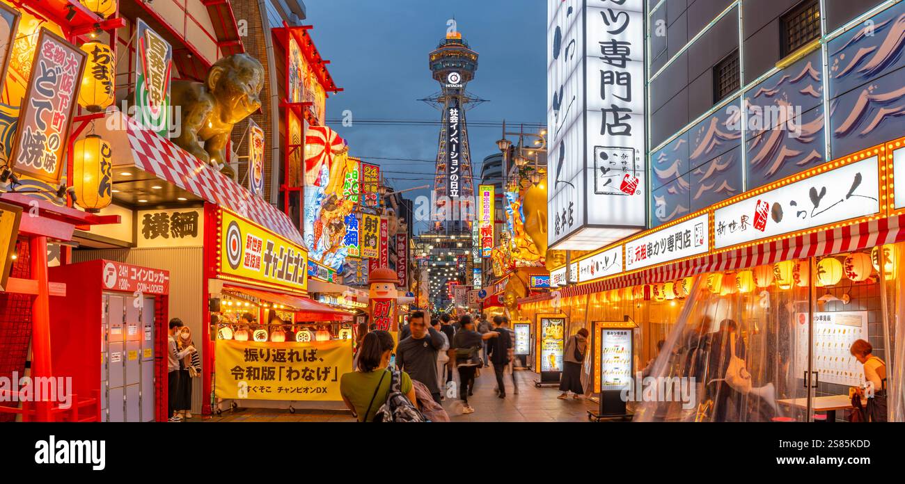 View of Tsutenkaku Tower and restaurants neon lights at dusk in the ...