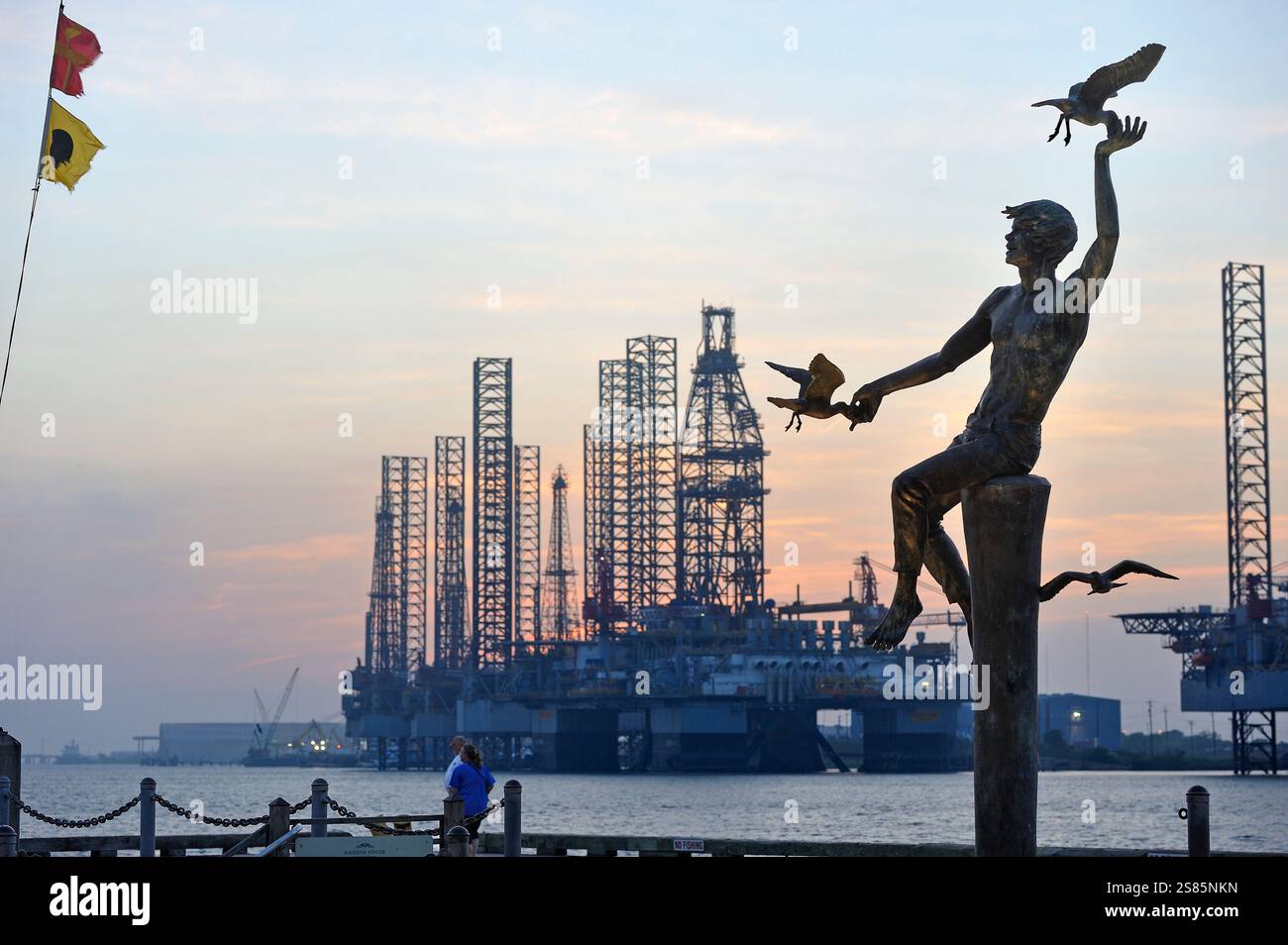 High Tide bronze statue by Charles Parks, oil platform beyond at sunset ...