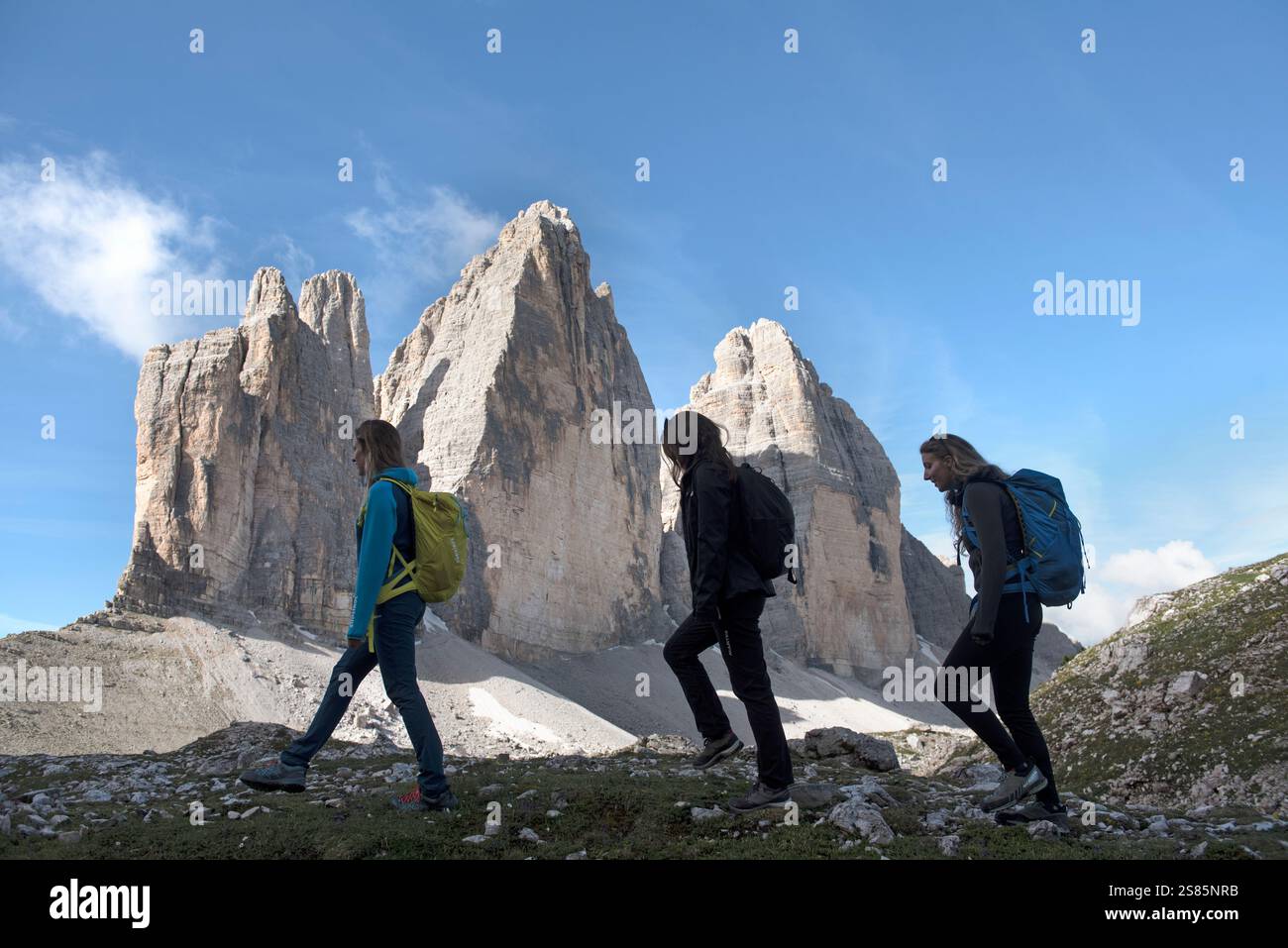Three hikers at foot of Tre Cime di Lavaredo (Three Peaks of Lavaredo ...