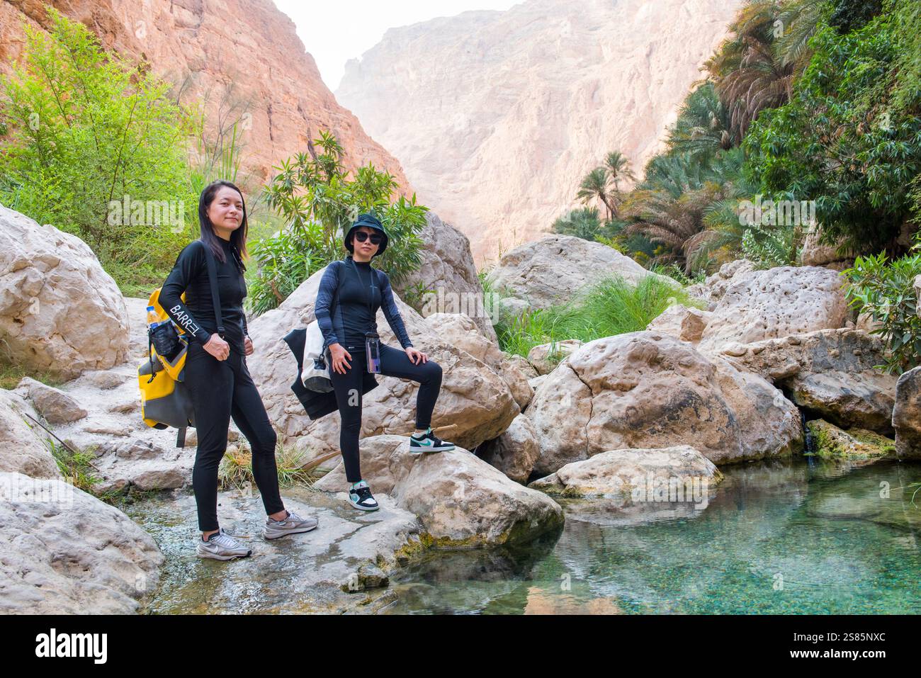 Two young women wearing canyoning gear in Wadi Shab, canyon near Tiwi ...