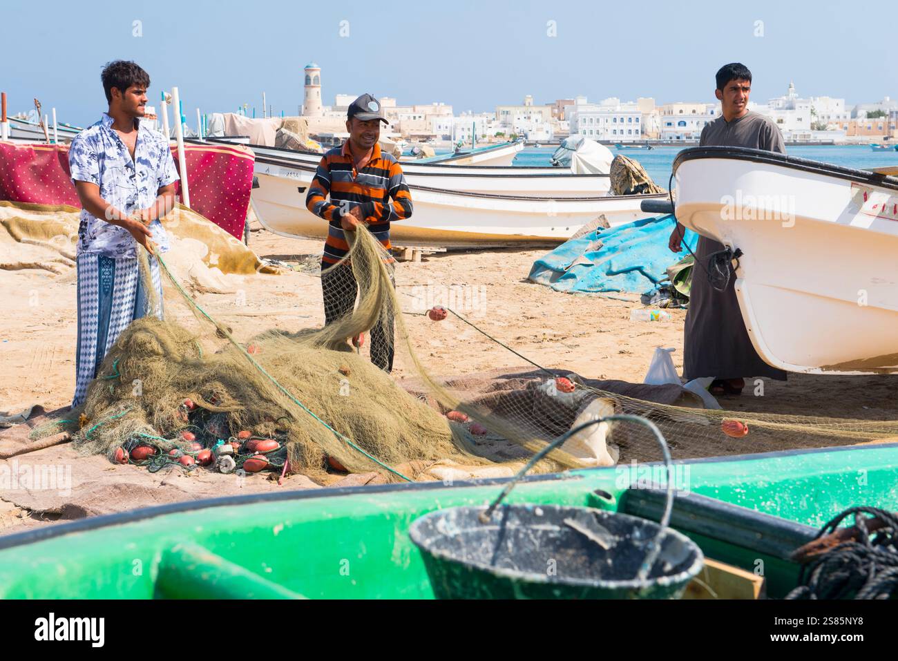 Fishermen on the beach in front of the Al Ayjah village, Sur, port-city ...