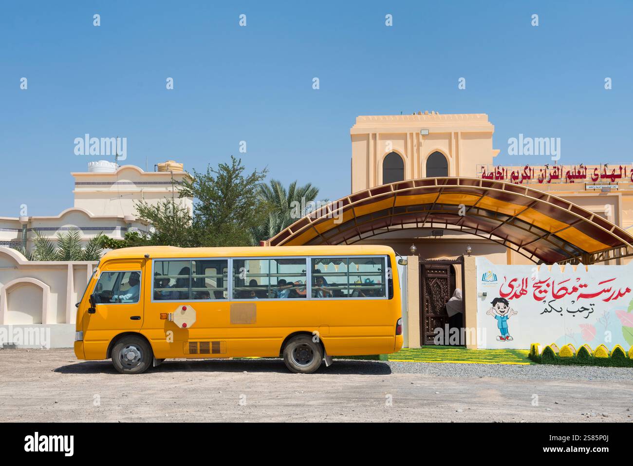 School bus in front of a school, Al Sharqiyah region, Sultanate of Oman ...