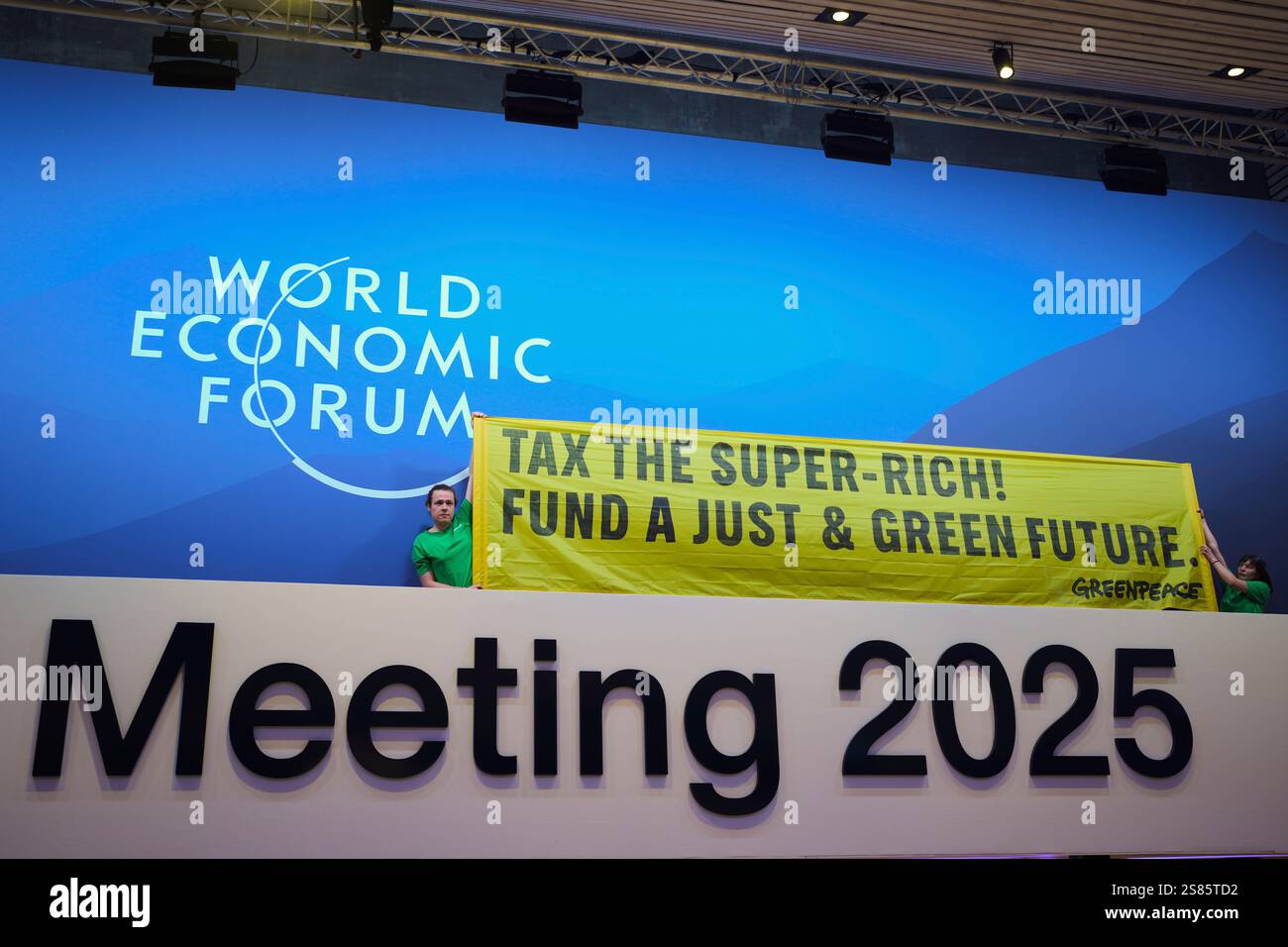 Greenpeace activists show a poster during a protest at the Annual ...