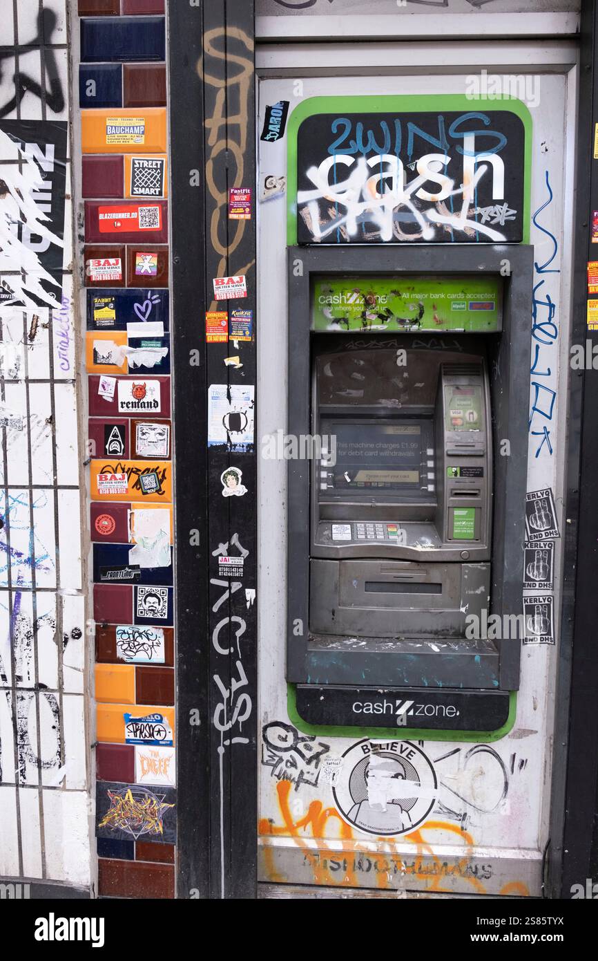 An urban ATM machine vandalised, covered in grafitti in Brick Lane East ...