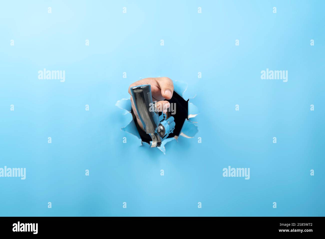 Human hand holding handgun through ripped paper. Hand gestures. Mockup ...