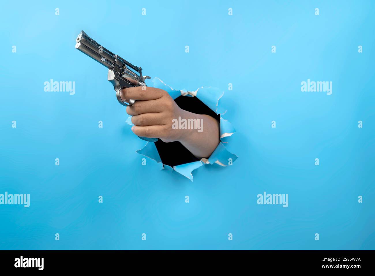 Human hand holding handgun through ripped paper. Hand gestures. Mockup ...
