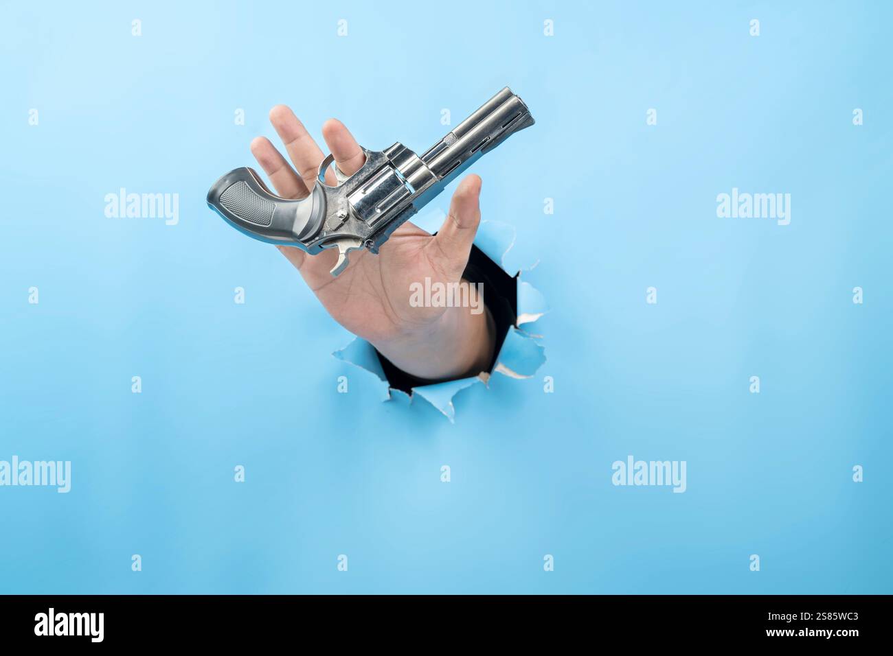 Human hand holding handgun through ripped paper. Hand gestures. Mockup ...