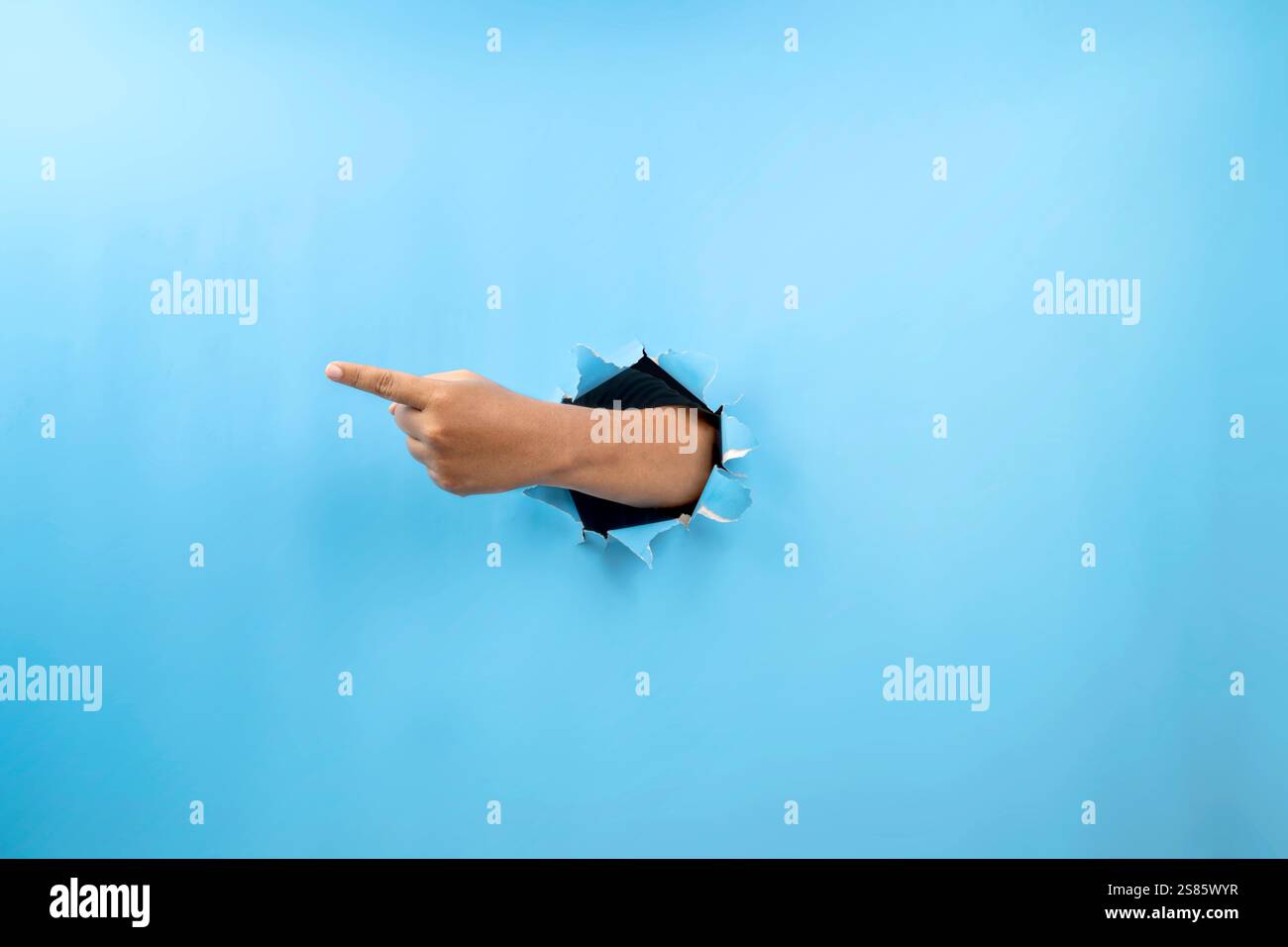 Human hand showing from ripped paper. Hand gestures of pointing aside ...