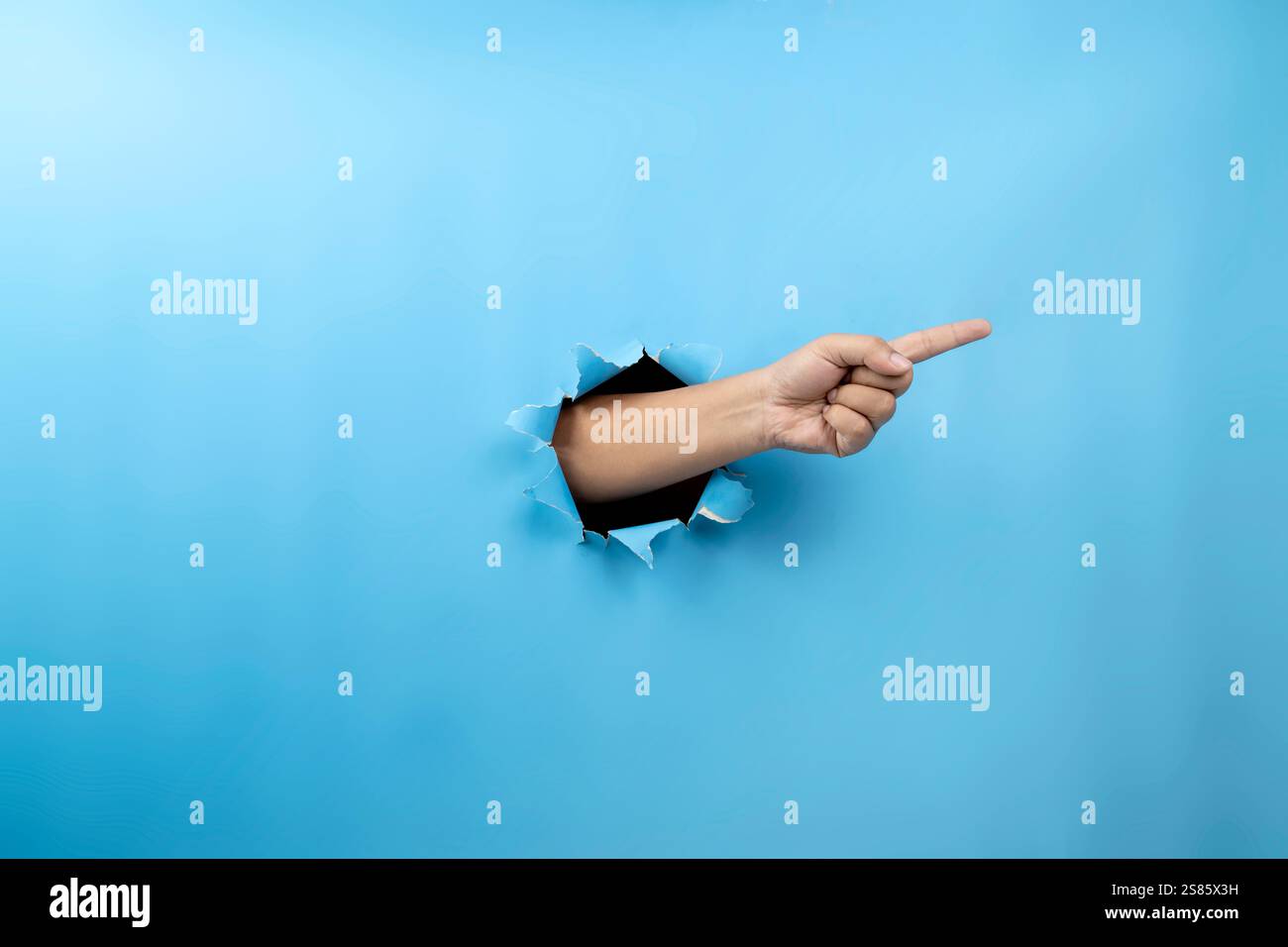 Human hand showing from ripped paper. Hand gestures of pointing aside ...