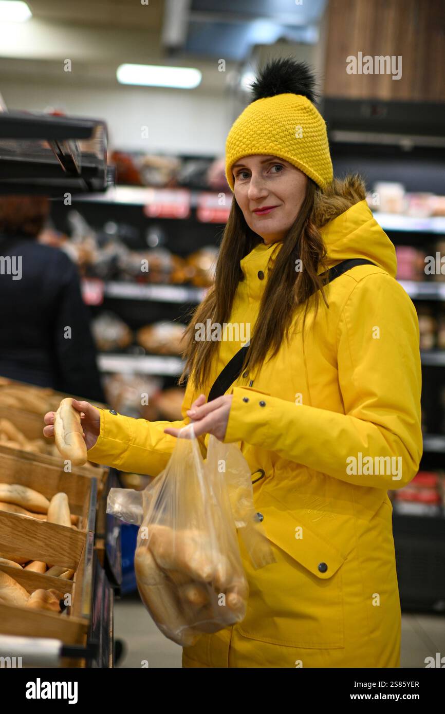 Customer buying bread rolls in supermarket, holding plastic bag and ...