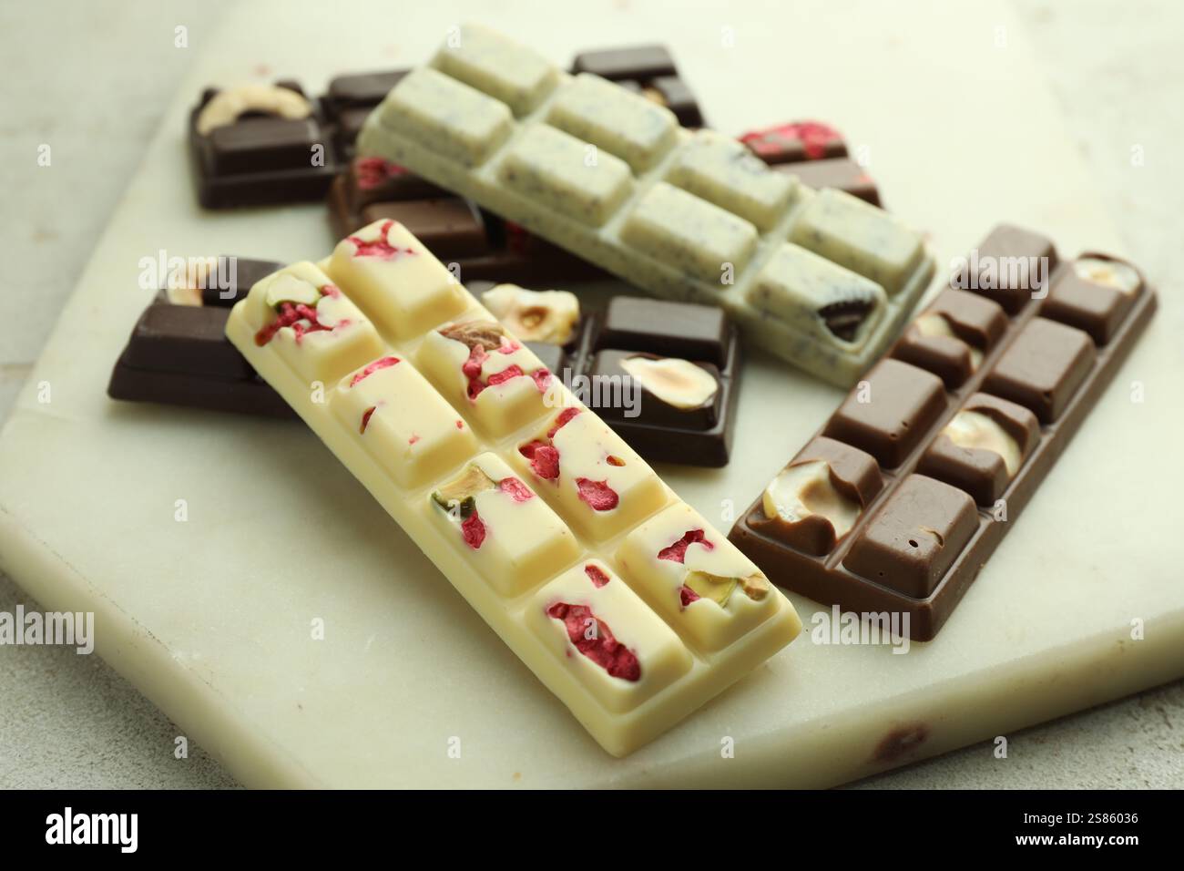 Delicious chocolate bars with different flavors on light table, closeup Stock Photo - Alamy