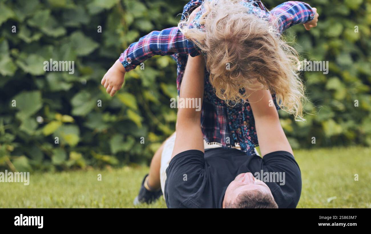 Father and daughter enjoying a playful moment in the garden ...