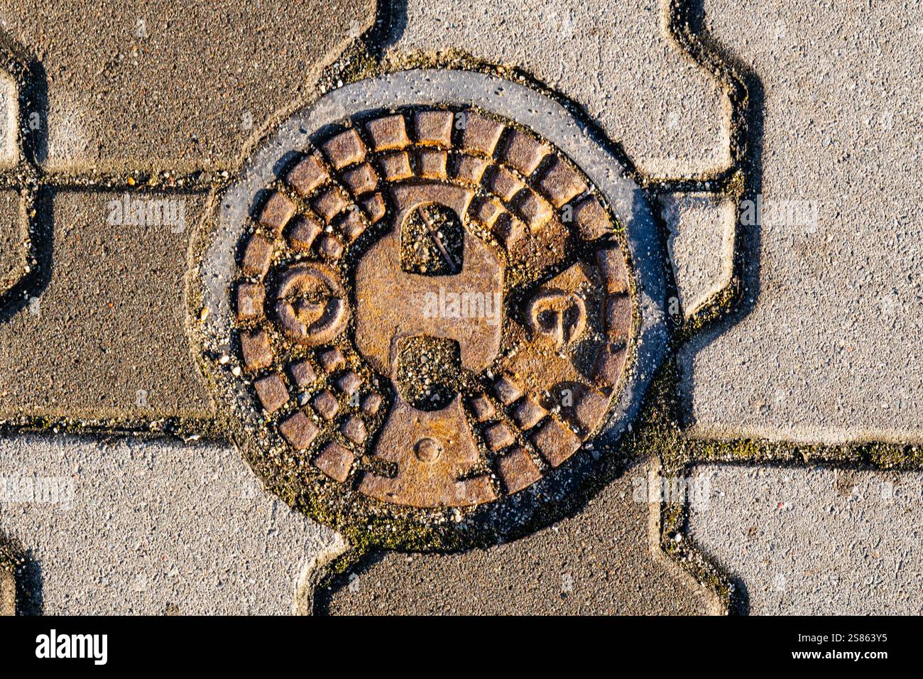 Manhole cover design embedded in pavement with texture and details in ...