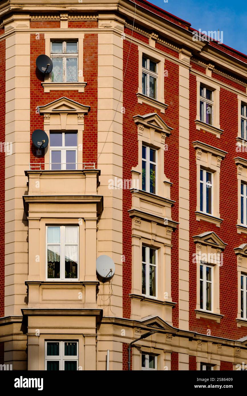 Brick apartment building with satellite dishes in urban setting under ...