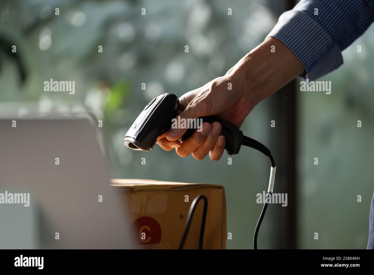 Focused small business owner using a handheld barcode scanner to ...