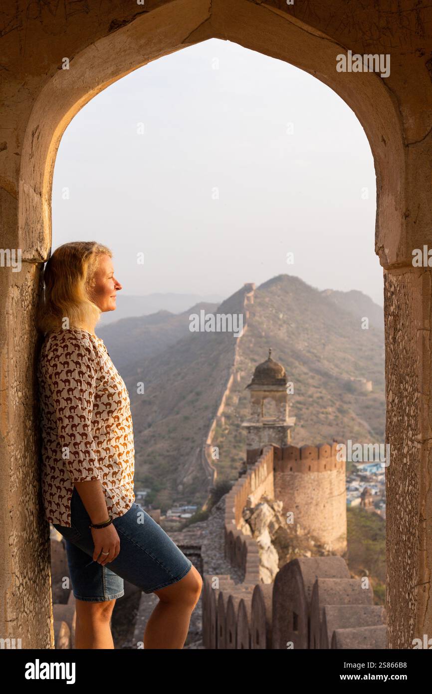 Young blonde woman enjoying sunrise on the Great Wall of Jaipur in ...