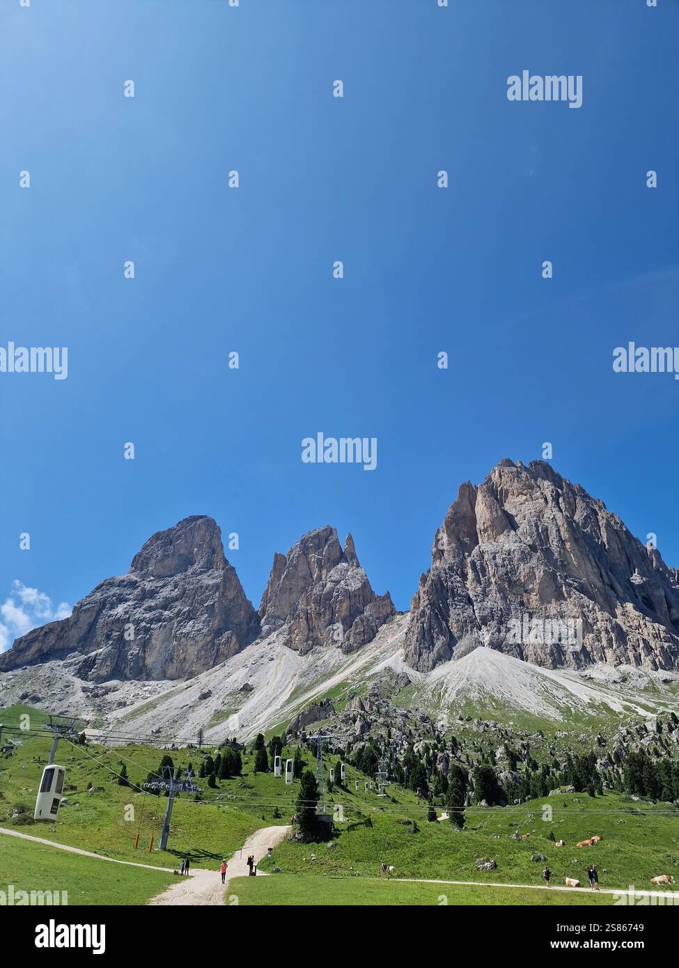 Stunning view of towering mountains under a bright blue sky with wispy ...