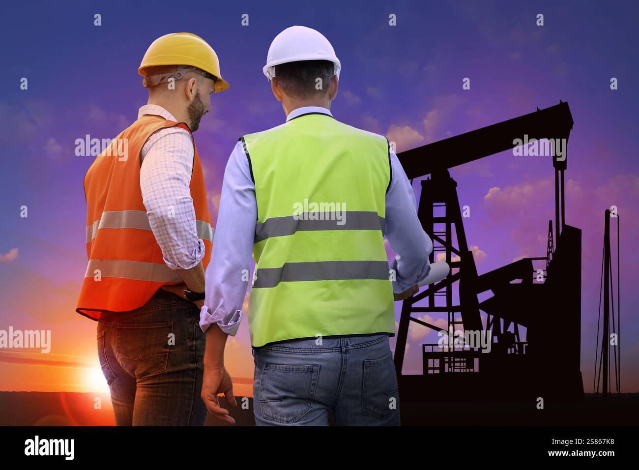 Workers at oil production site with crude oil pump Stock Photo - Alamy