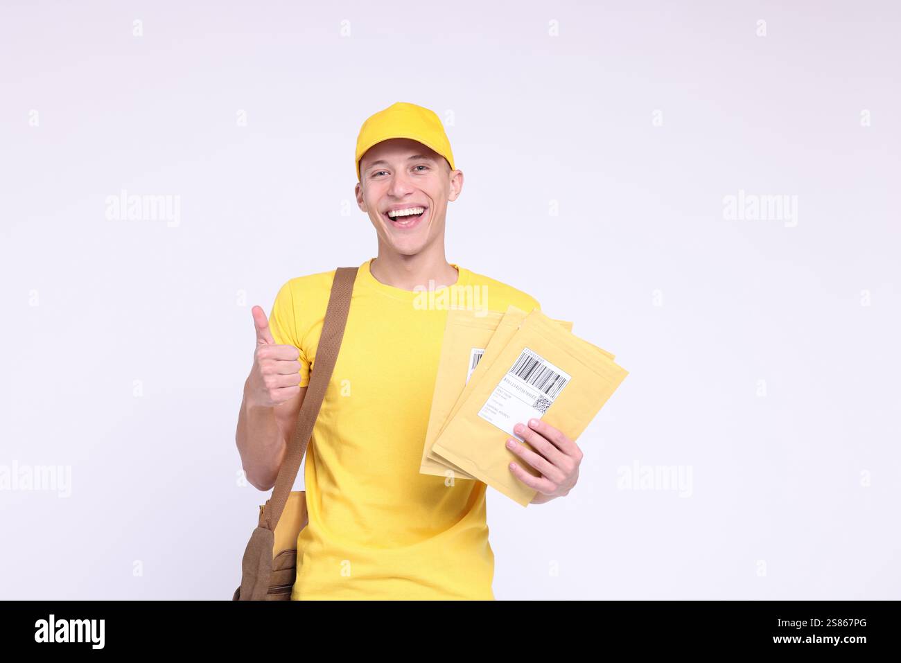 Happy postman with bag and envelopes showing thumbs up on white ...