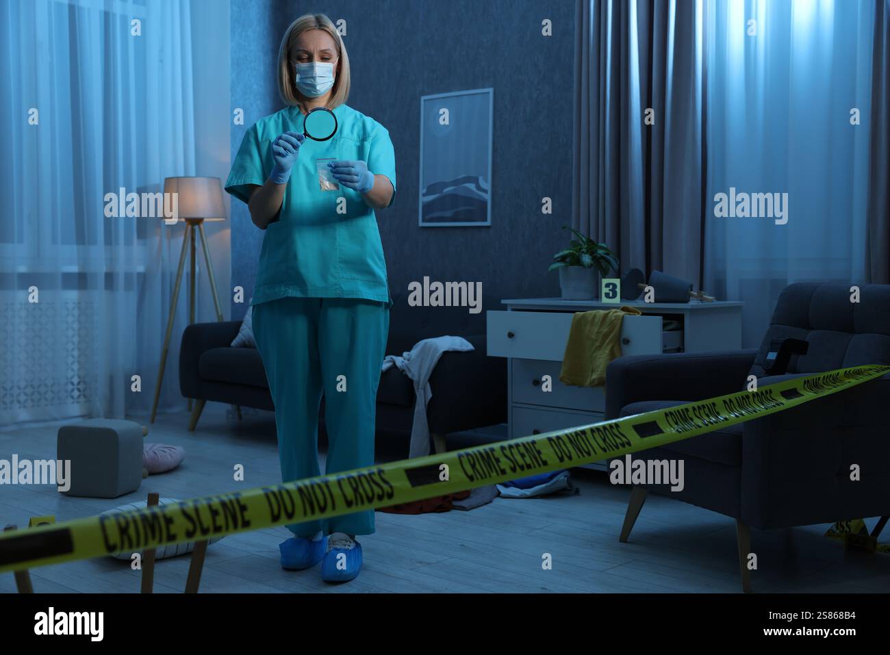 Forensic expert examining plastic bag with drug powder through ...