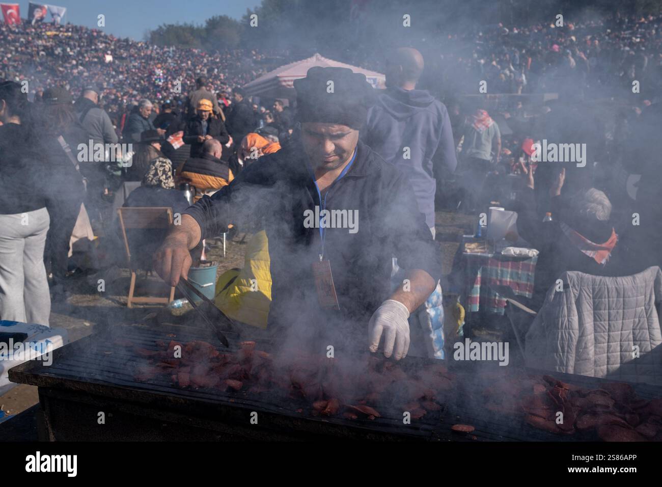 A man cooks sausage on a barbecue at the wrestling grounds. Camel ...