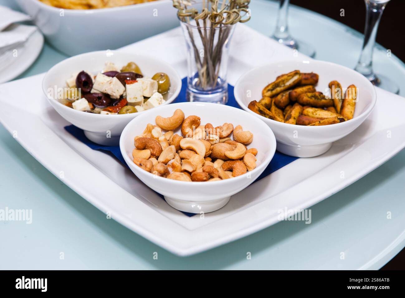 A table of nibbles, canapes etc. including nuts, crisps and olives at a ...