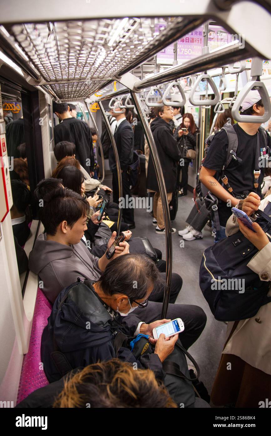 Commuters and travellers on an underground train in Tokyo, Japan Stock ...