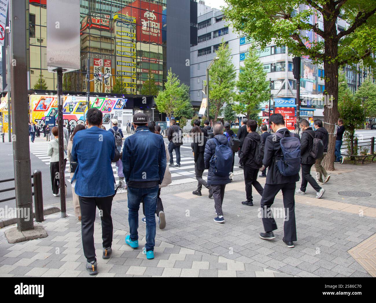 People crossing a road in the Akihabara district of Tokyo in Japan ...