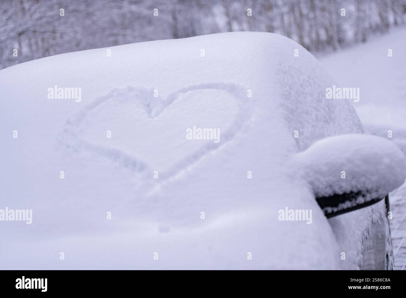 The front of the car with heart drawing in the snow after blizzard ...