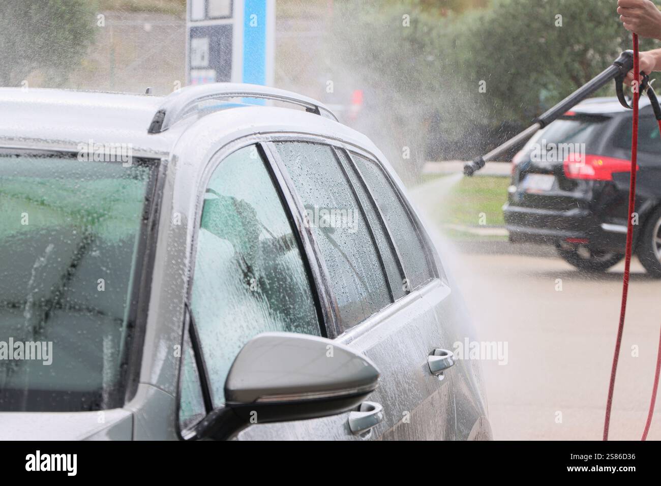 The car is washed at a car wash. The pressurized water jet cleans the ...