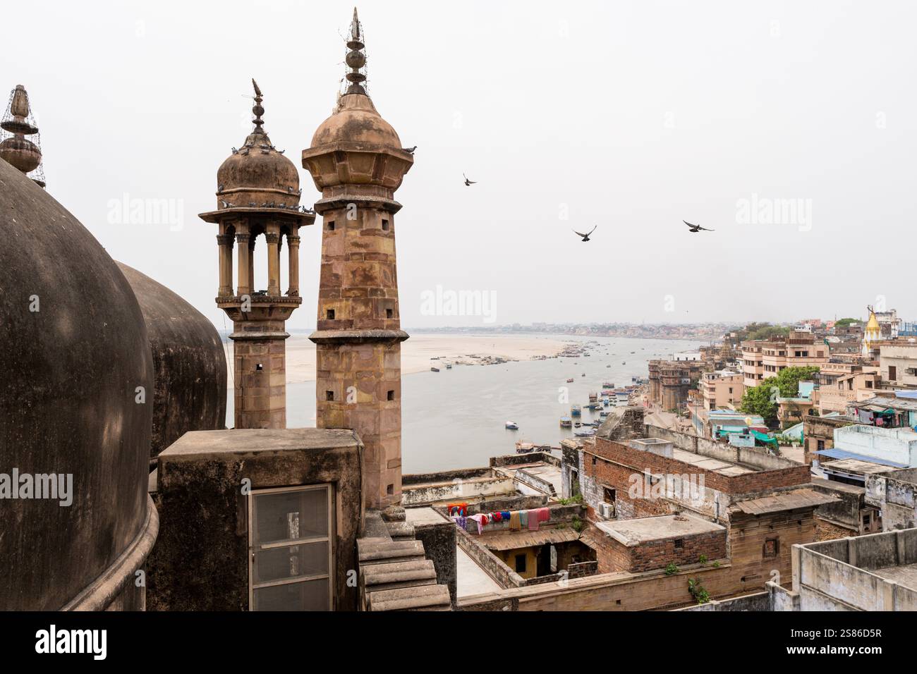 Aerial view over Varanasi old town, mosque minarets and Ganges river in ...
