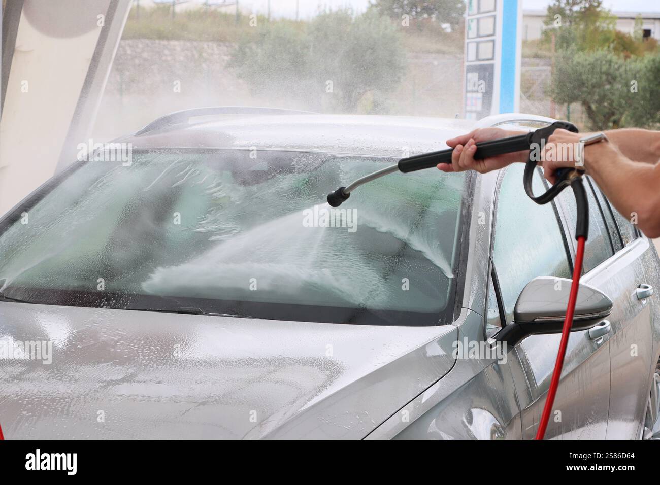 The car is washed at a car wash. The pressurized water jet cleans the ...