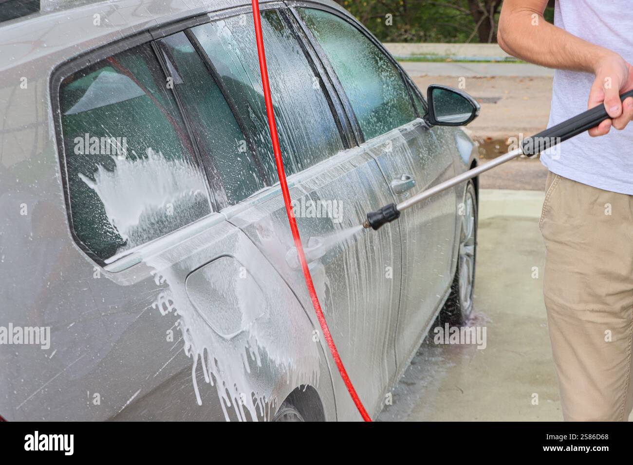 The car is washed at a car wash. The pressurized water jet cleans the ...