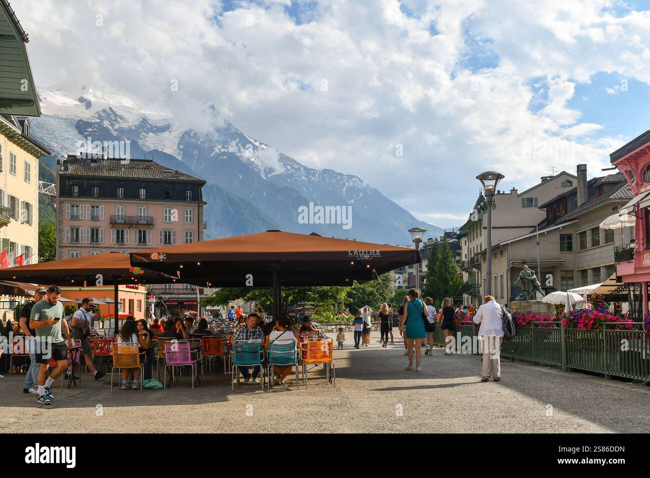 People in an outdoor bar in the centre of the alpine town, with the ...