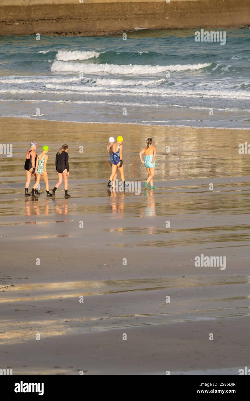 A group of female cold water swimmers walking to the sea for an early ...