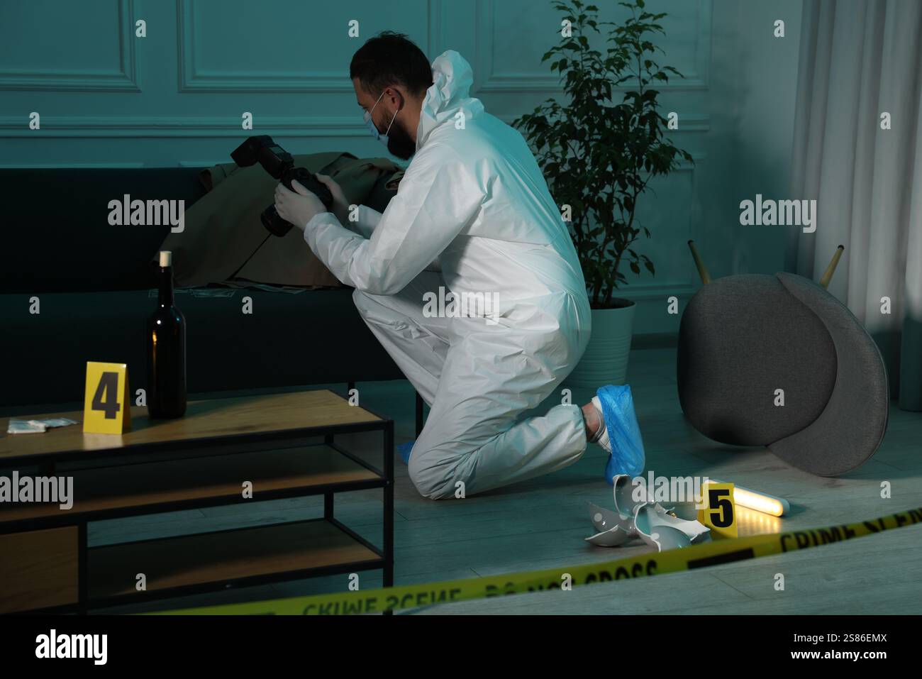 Forensic expert with camera taking photo of evidences at crime scene ...