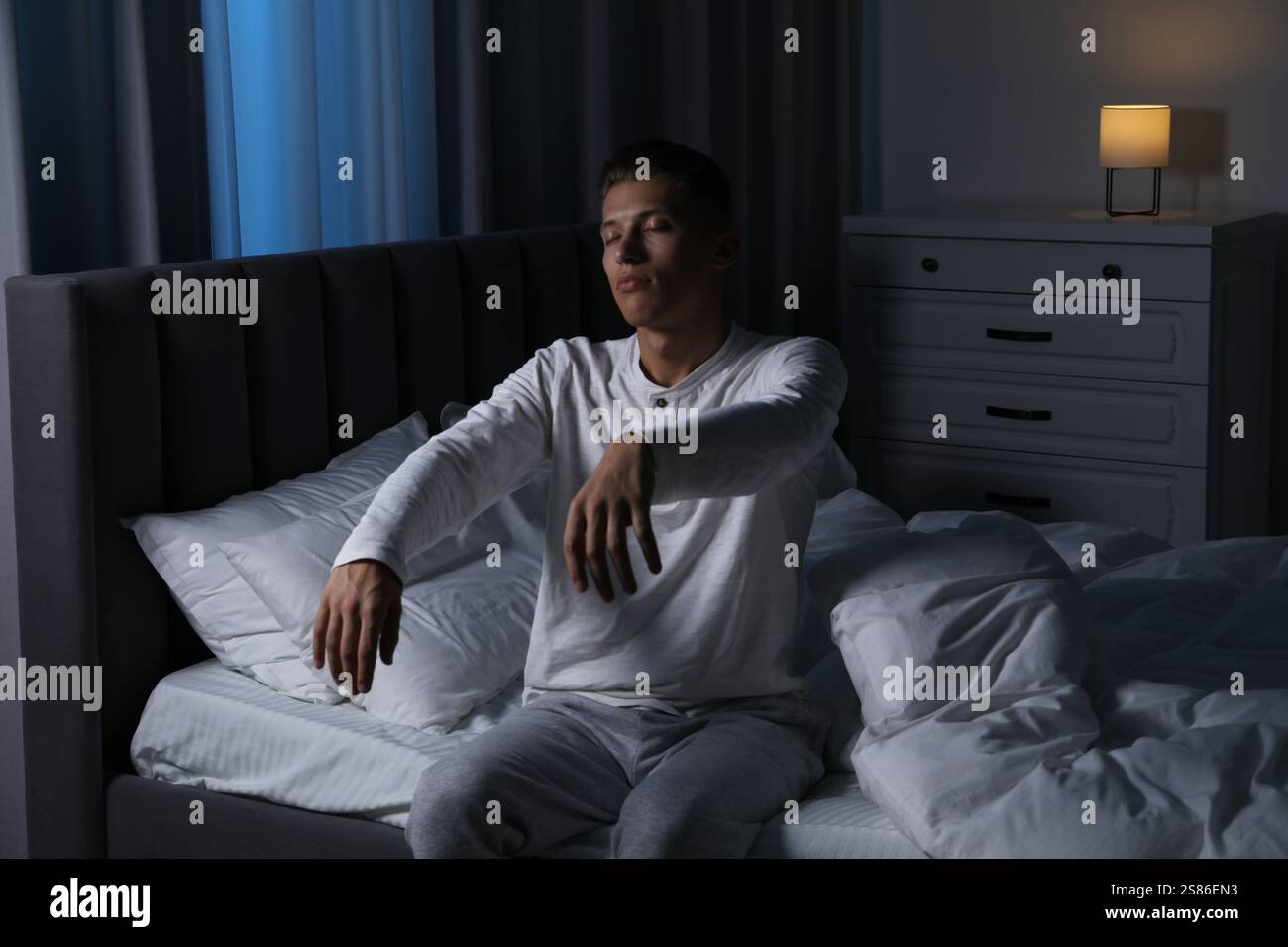 Young man suffering from sleepwalking on bed at home Stock Photo - Alamy