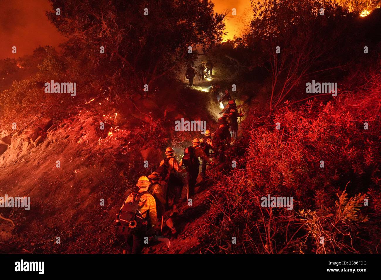 Firefighters walk up a ridge to battle the Lilac Fire in Bonsall, Calif ...
