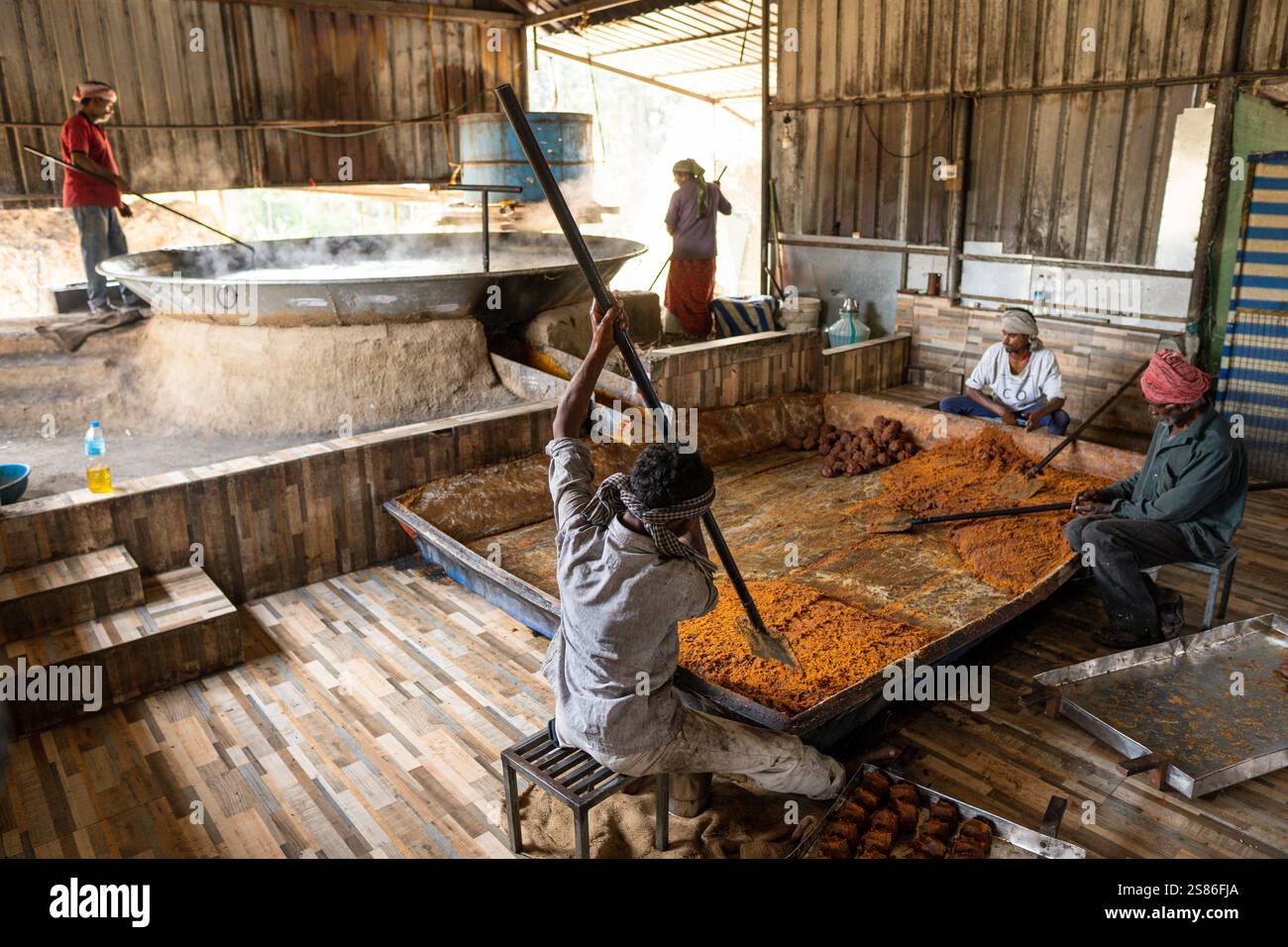 MARAYOOR, INDIA - MAY 2, 2024: Indian men working in jaggery cane sugar traditional processing ...