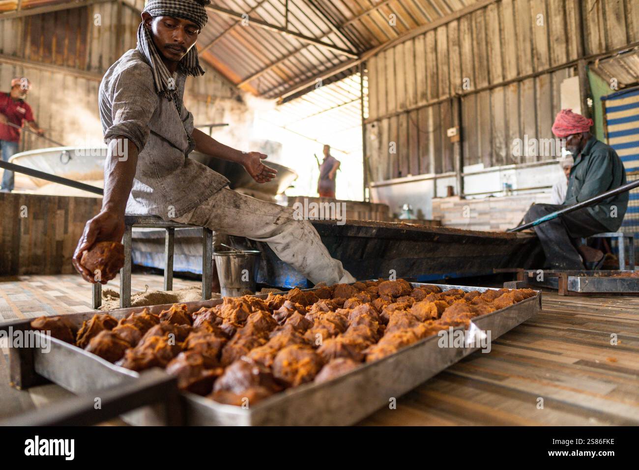 MARAYOOR, INDIA - MAY 2, 2024: Indian men working in jaggery cane sugar traditional processing ...
