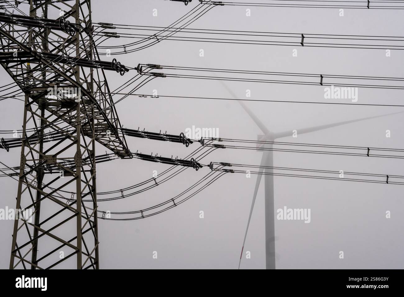 Wind farm in the fog, high-voltage pylons, dark doldrums, no wind no ...