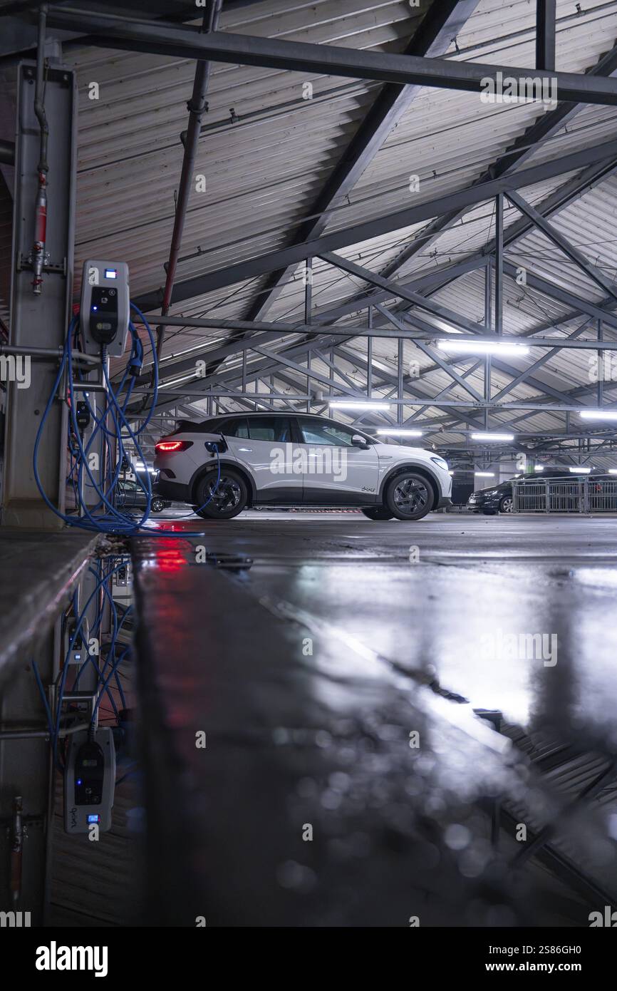An electric vehicle is connected to a charging station in the multi ...