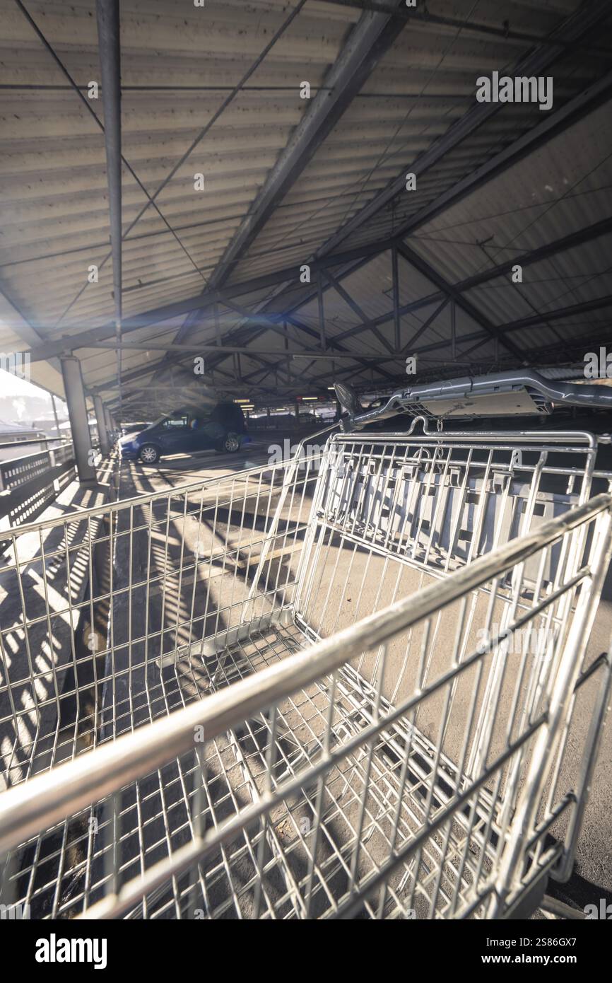 Shopping trolley under a covered area with steel beams and sunlight ...