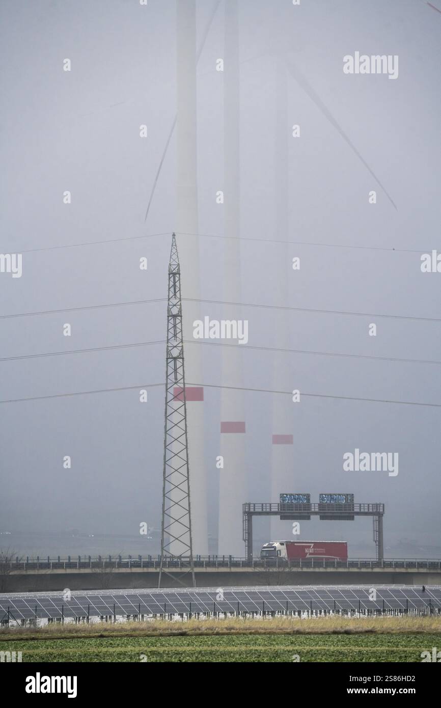 Wind farm in the fog, photovoltaic system, on the A44 motorway, dark ...
