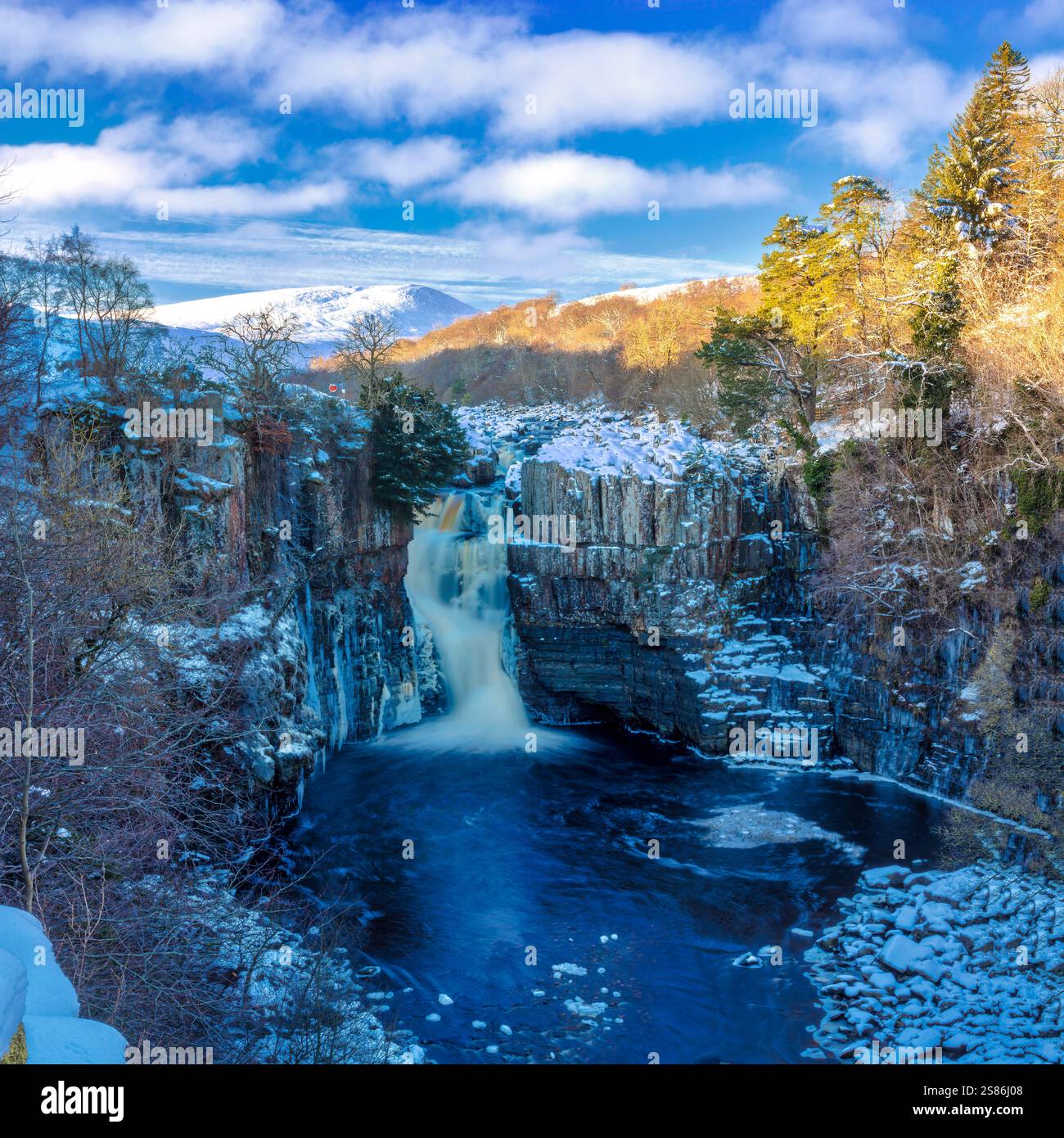 A view of High Force in Winter with snow and ice and blue skies near ...