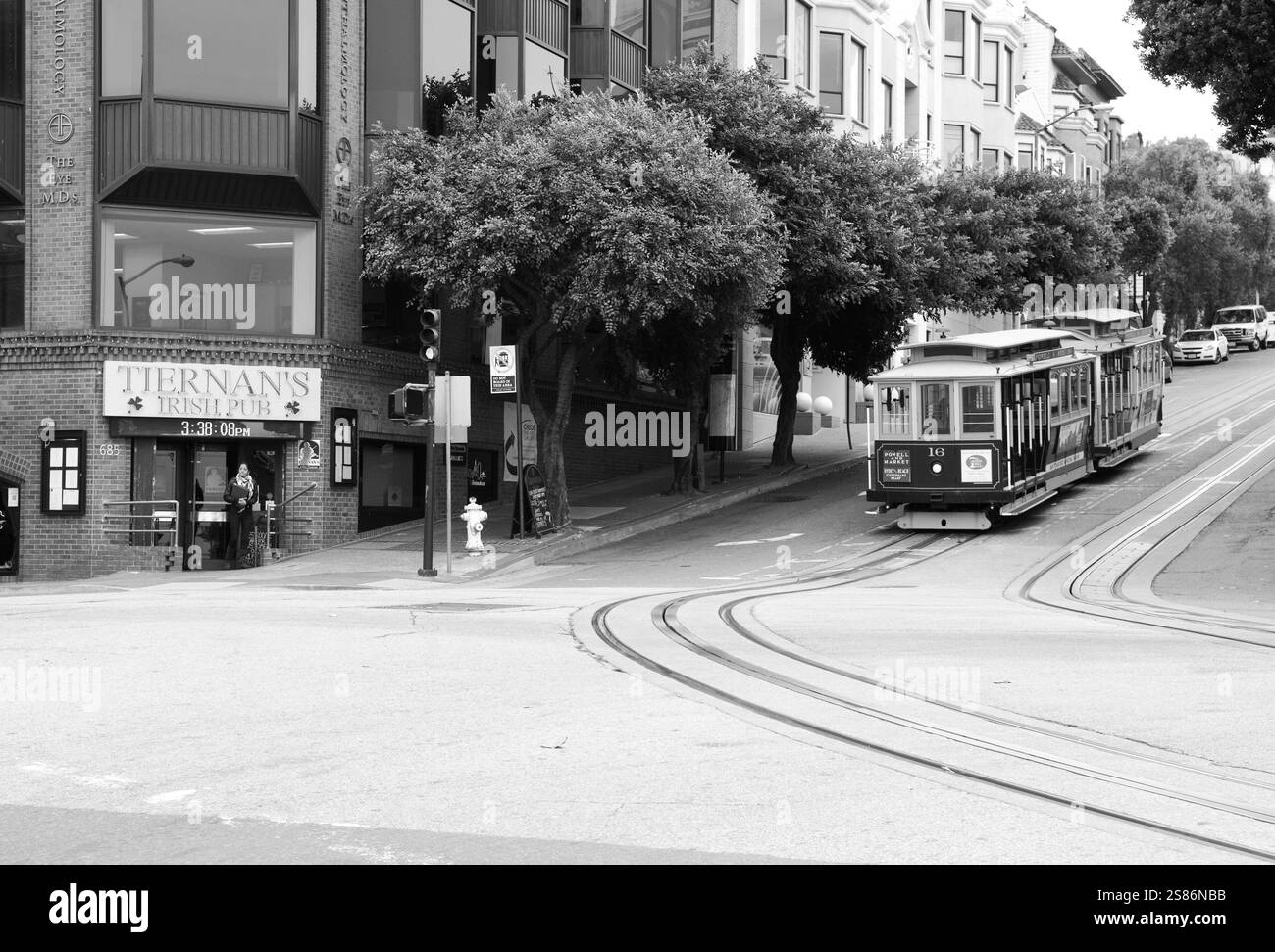 Iconic San Francisco cable car at the base of a hill, surrounded by ...