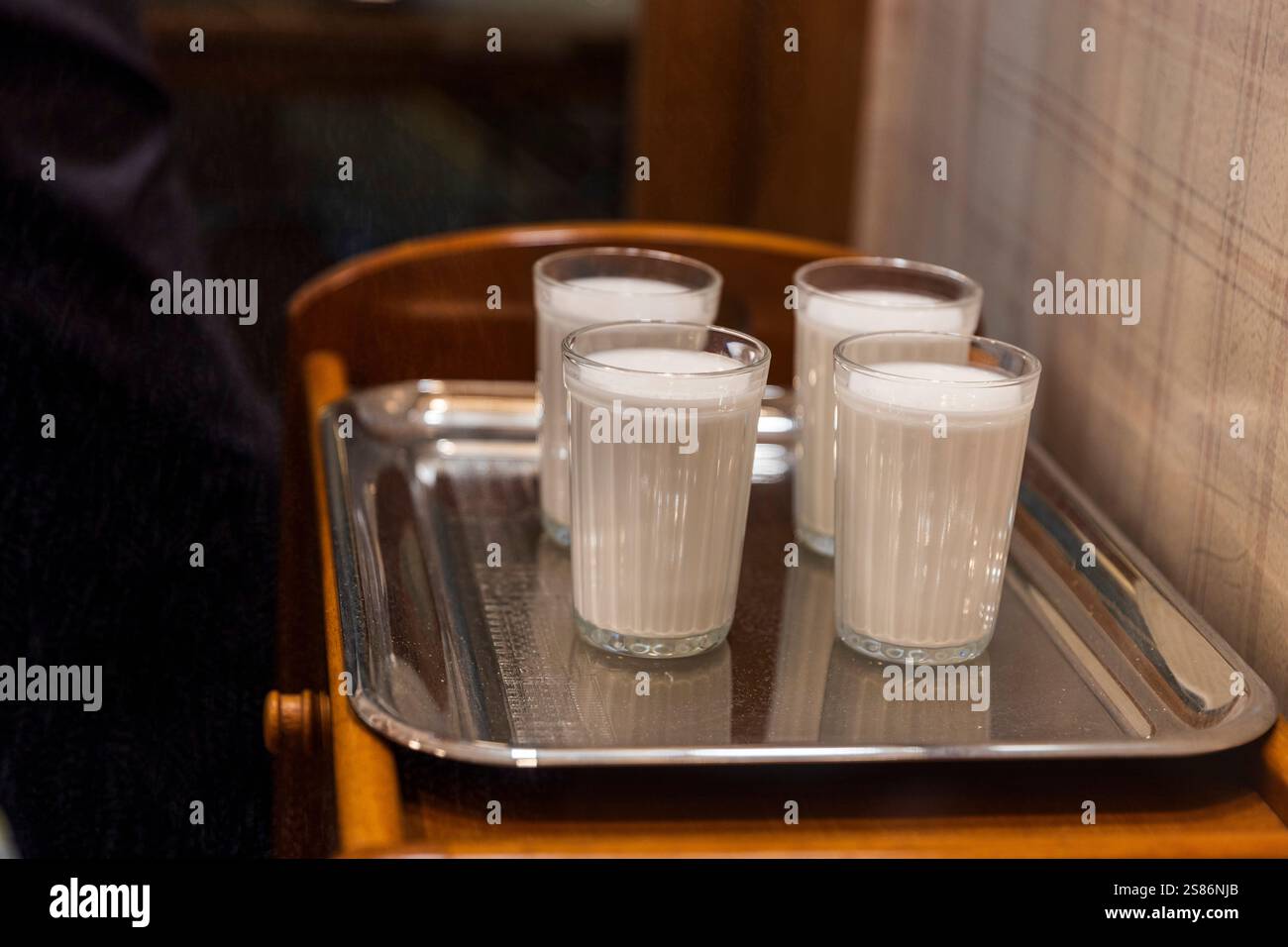 Four glasses of milk on a steel tray in a cafeteria Stock Photo - Alamy