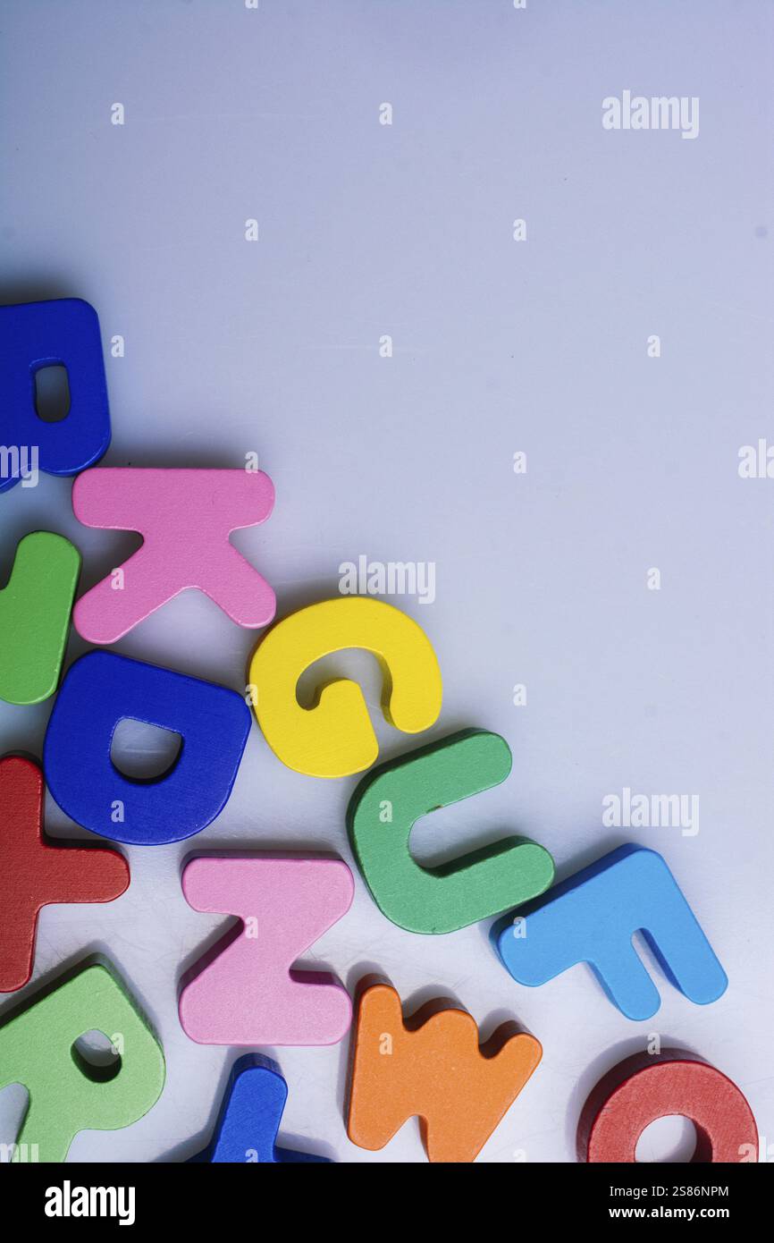 Colorful wooden letters scattered on a white background Stock Photo - Alamy